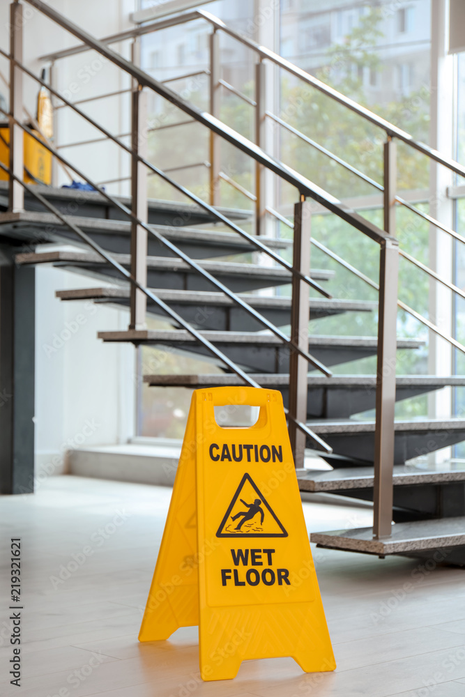 Safety sign with phrase Caution wet floor near stairs. Cleaning service ...
