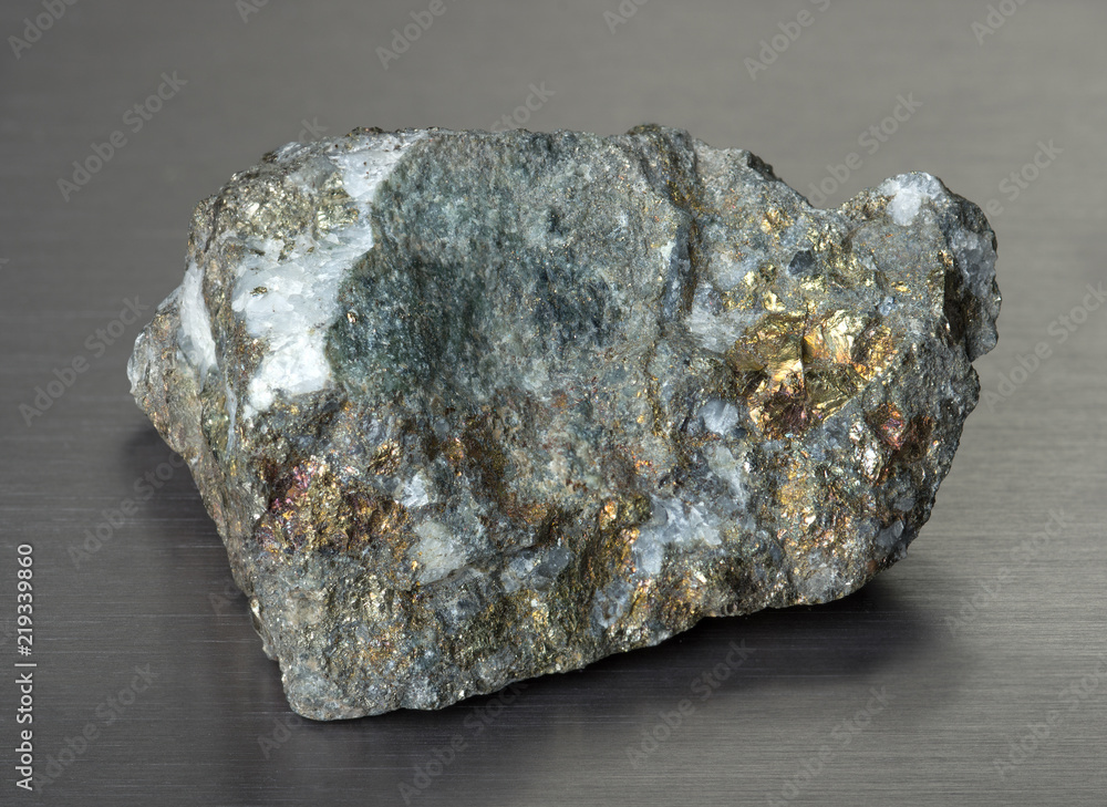 Specimen of mineral chalcopyrite (copper pyrite) on gray background ...