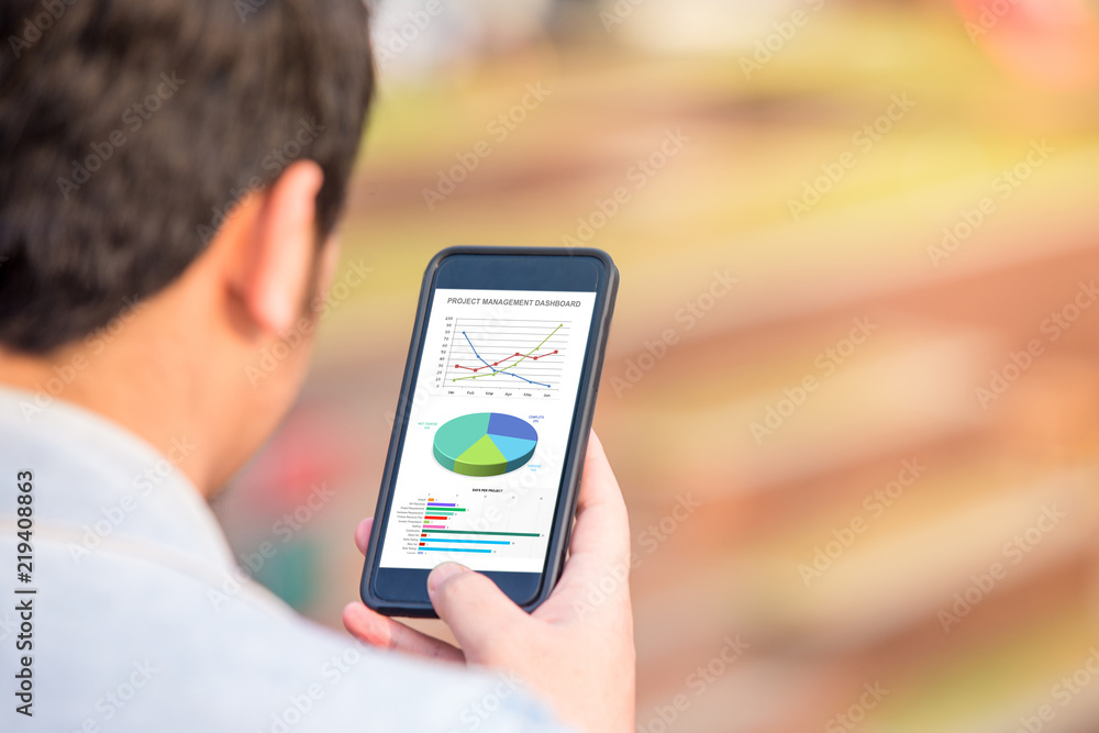 Project management dashboard concept. Man holding phone with project ...
