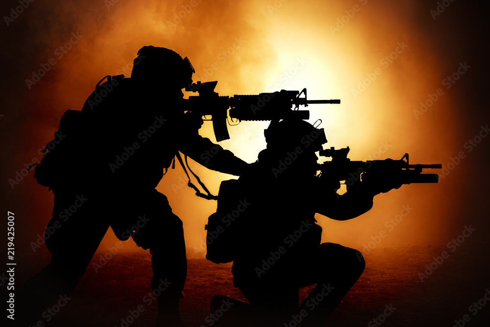 Silhouettes of two army soldiers, U.S. marines team in action ...