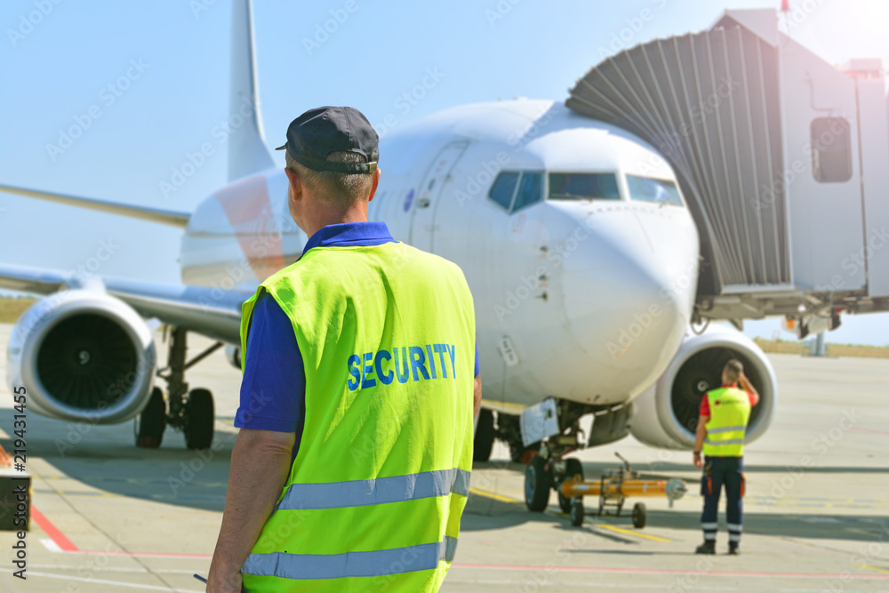 Airport security at work. Security guard monitors the situation near ...