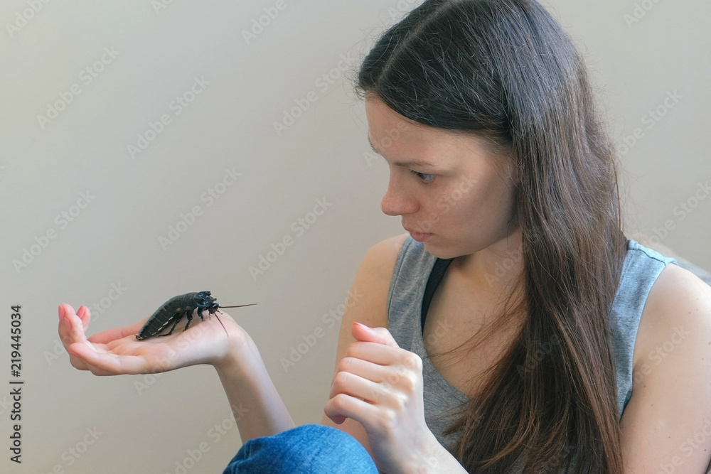 Young woman holding a male of Gromphadorhina portentosa the hissing ...