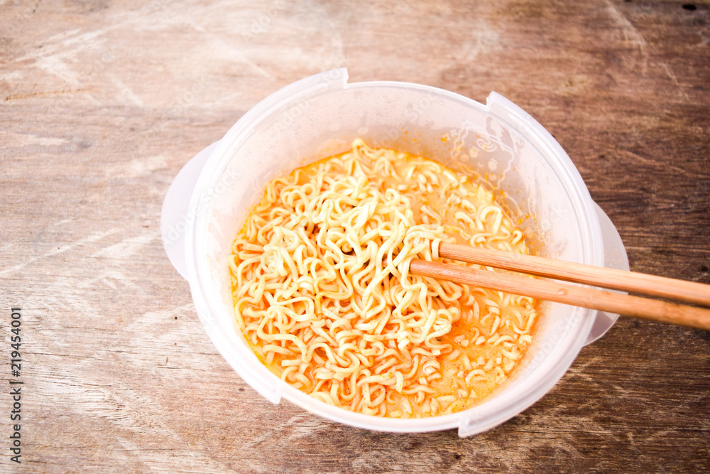 Hand uses chopsticks to pick up tasty noodles, instant noodles in a ...