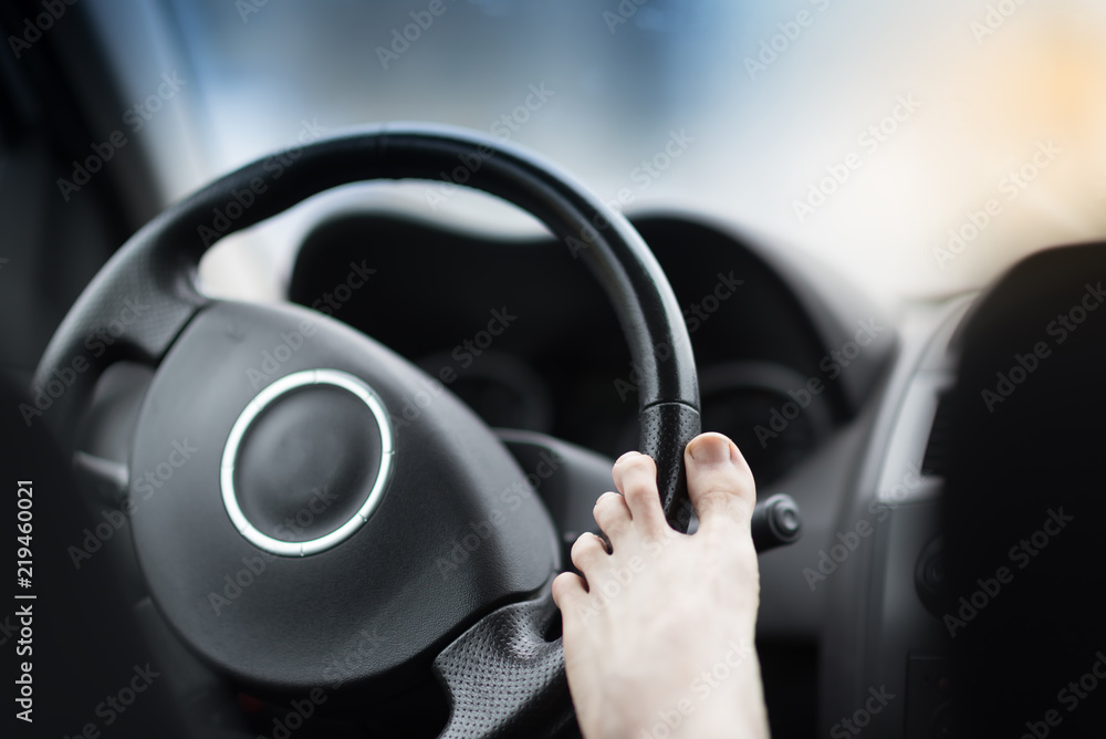 Leg Driver on the Steering Wheel of the Car in the Car. Very dangerous ...