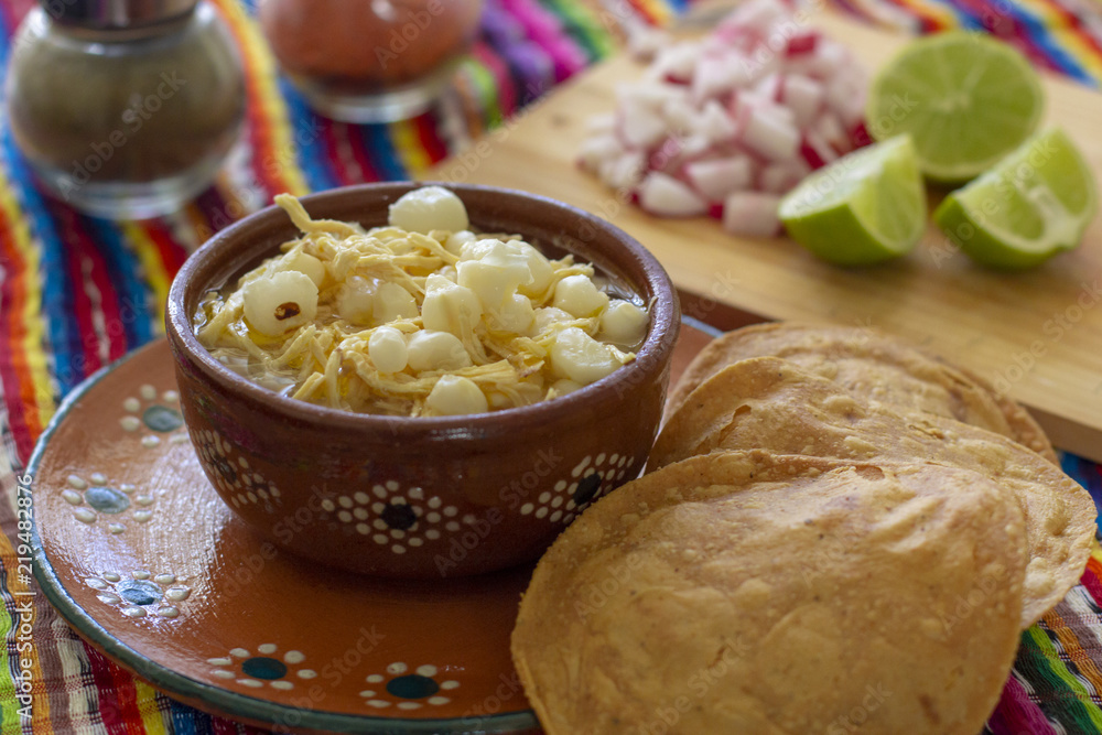 Pozole blanco con pollo, acompañado con rábanos, limones y tostadas en ...