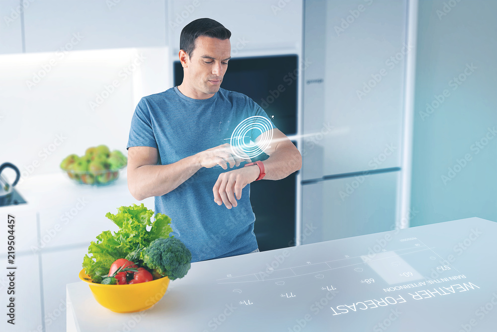 Convenient system. Calm concentrated young man standing in a modern ...