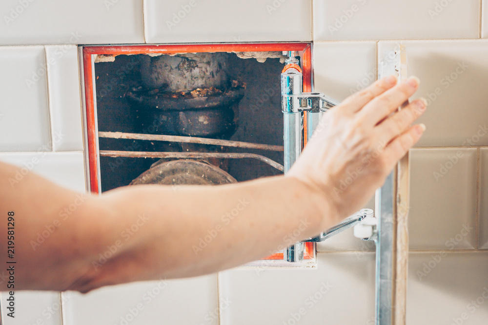Foto de The girl opens a hidden hatch on the wall of the tile to access ...