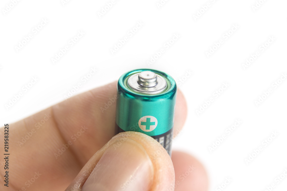 Tip of the fingers holds alkaline battery Stock Photo | Adobe Stock