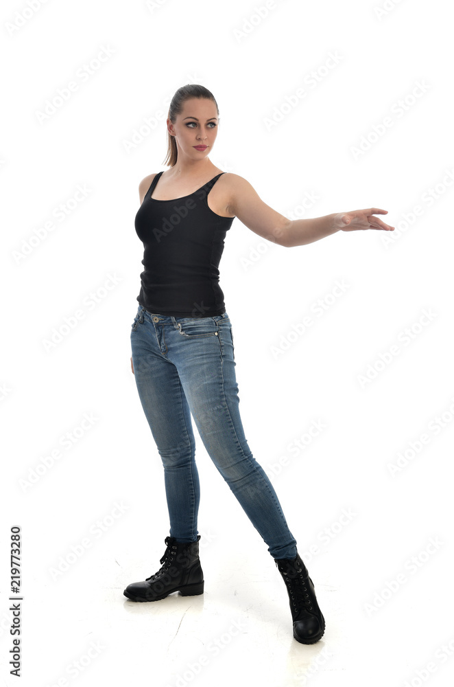 full length portrait of brunette girl wearing black single and jeans ...