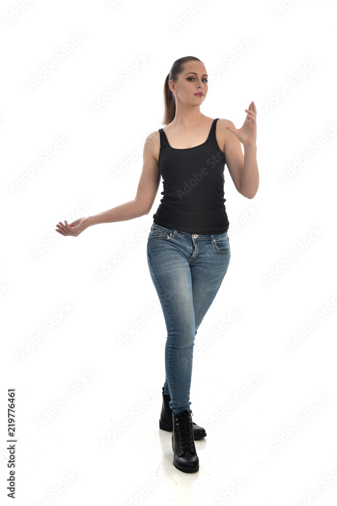 full length portrait of brunette girl wearing black single and jeans ...