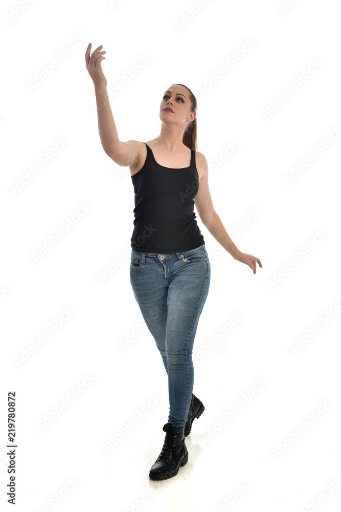 full length portrait of brunette girl wearing black single and jeans ...