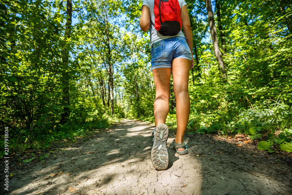 Young girl backpacker in jeans shorts with red backpack and sandals on ...