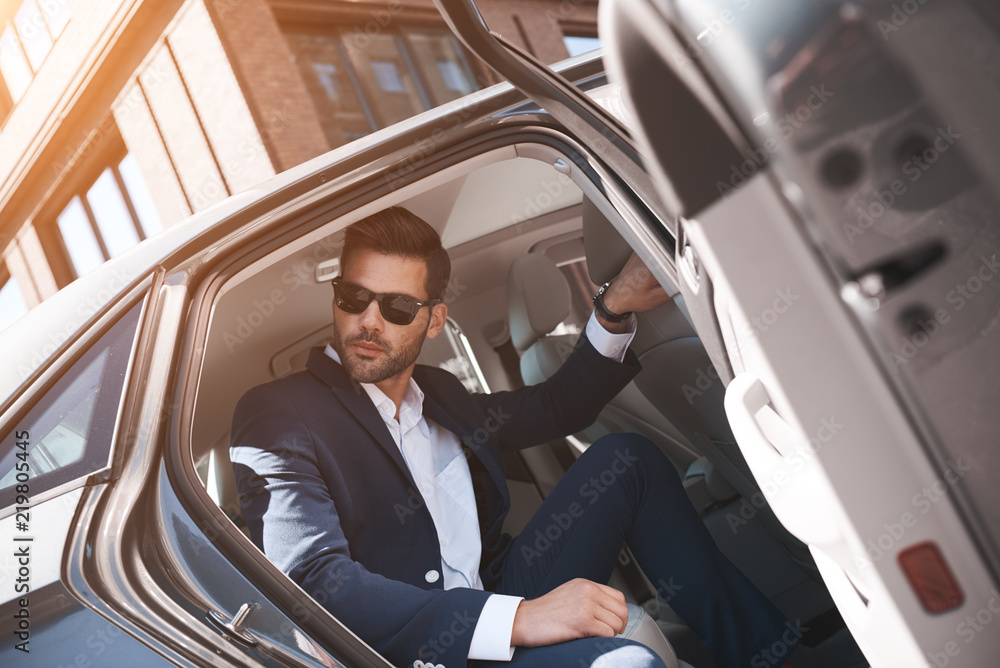 Confident businessman. Fashionable man coming out of a car Stock Photo ...