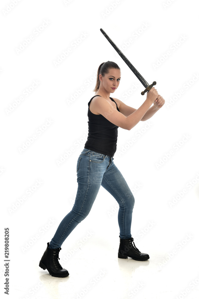full length portrait of brunette girl wearing black single and jeans ...