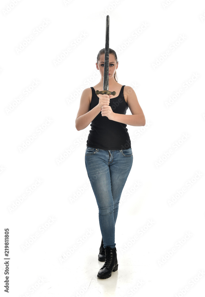 full length portrait of brunette girl wearing black single and jeans ...
