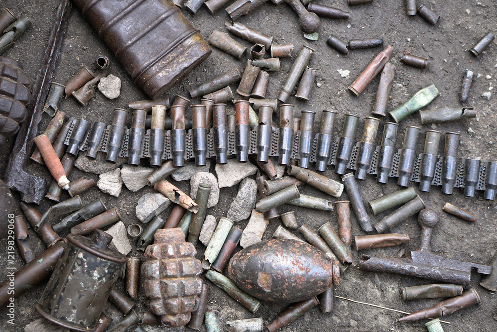 Military background with cartridges of grenades and machine-gun tape ...