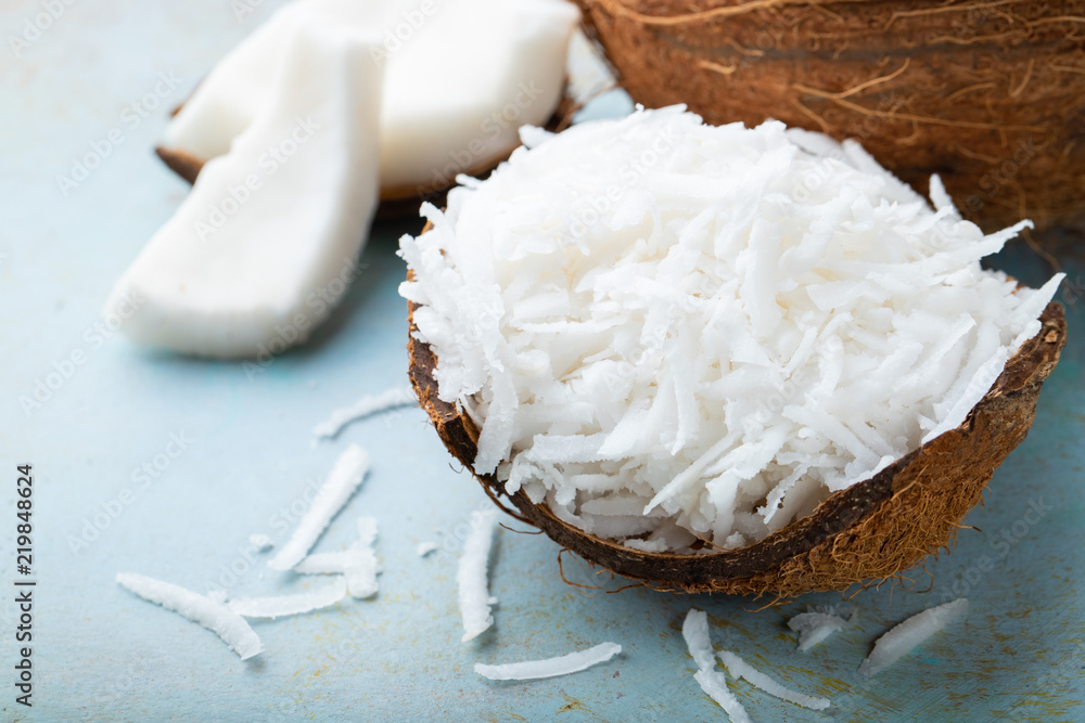Coconut flakes in a shell on a blue background Stock Photo | Adobe Stock