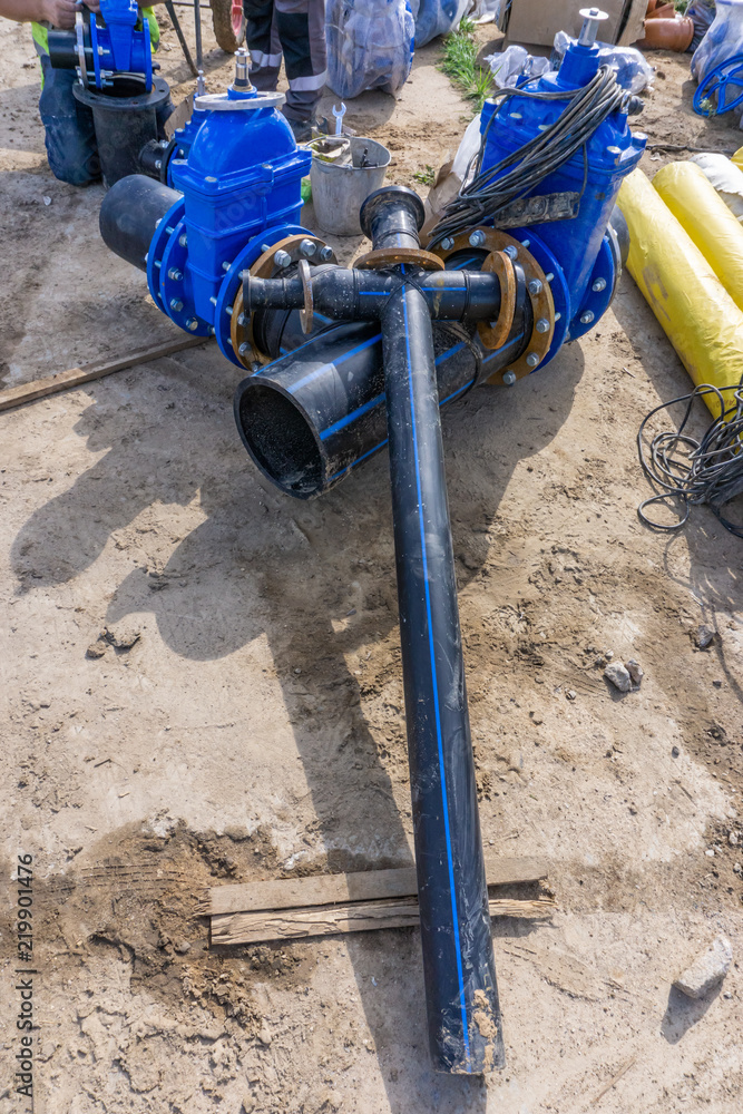 Elements of the pipeline, plastic pipes, cast iron valve at a ...