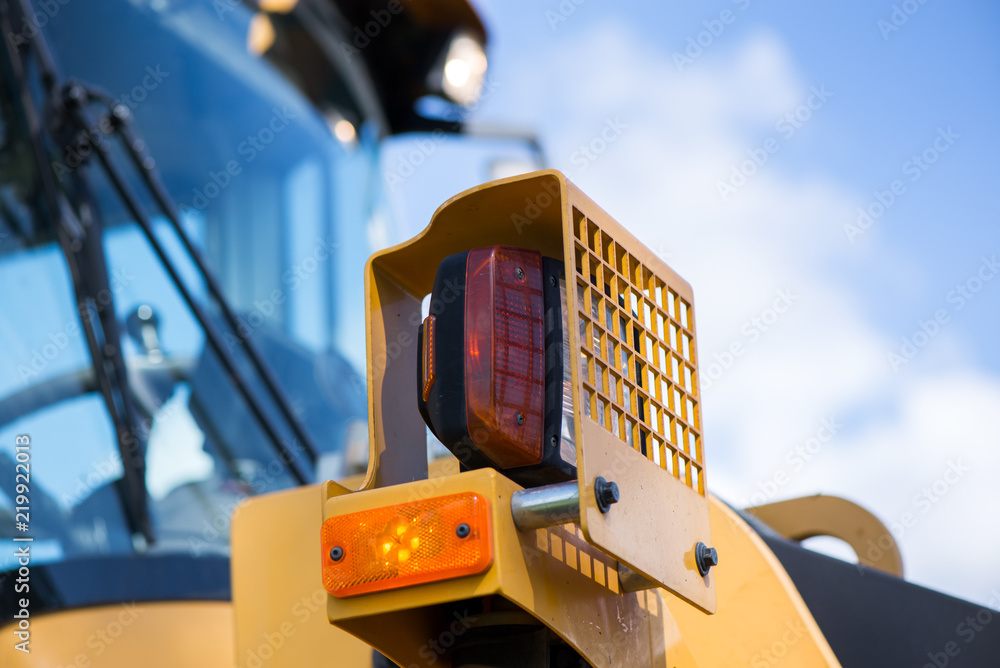 Yellow warning lights on excavator. Road construction workers repairing ...