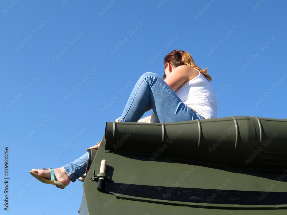 Girls in jeans sitting on the armor of an armored personnel carrier ...