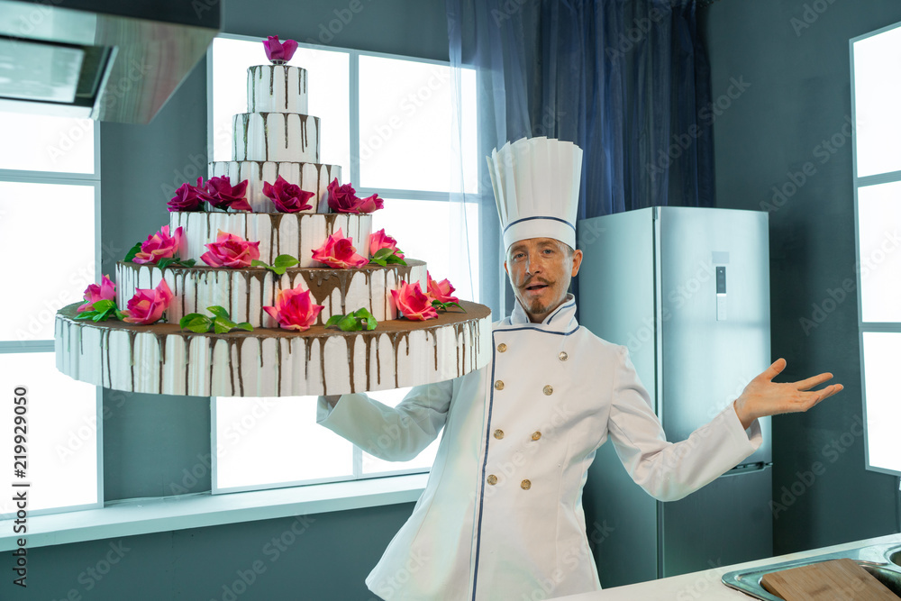 Chef in hand holding a huge cake Stock Photo | Adobe Stock