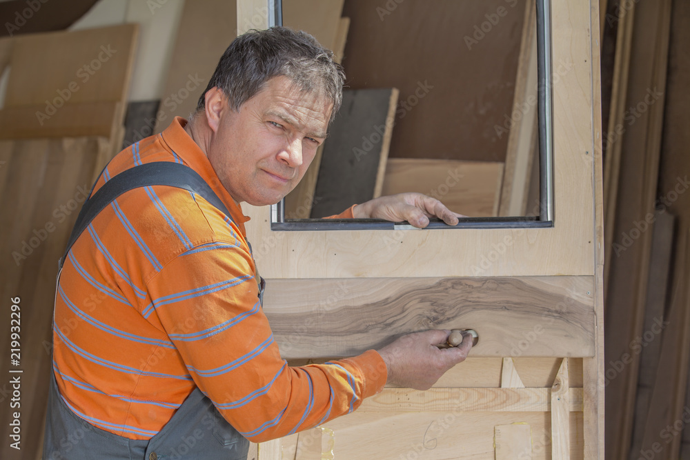 Elder carpenter caught in the moment of designing and shaping wooden ...