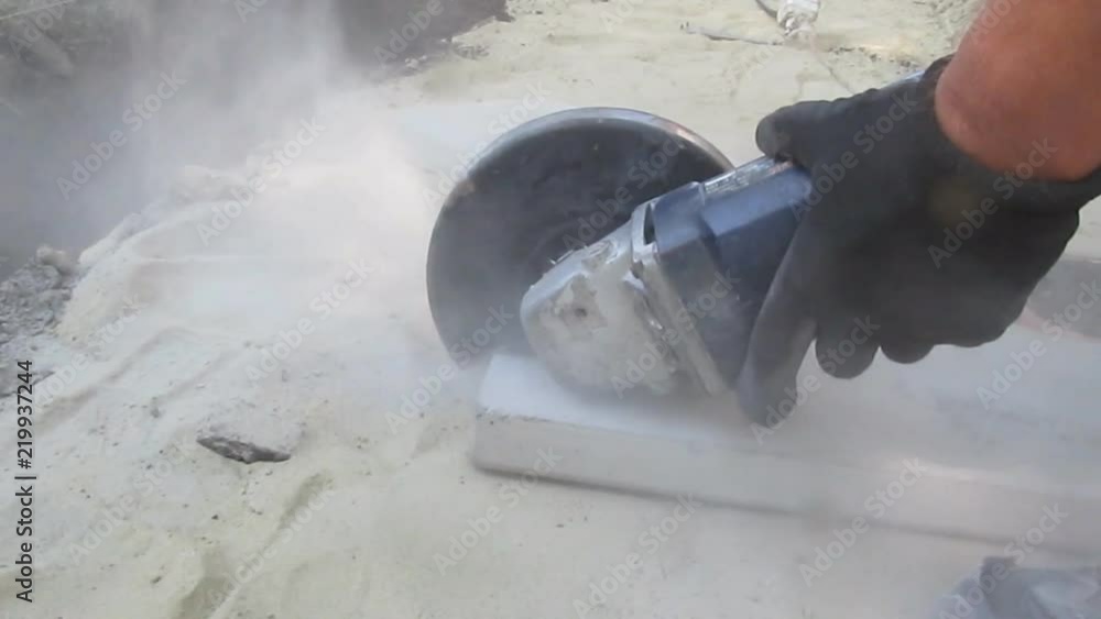 Cutting the concrete slab with an angle grinder - 15s. Male hands in ...