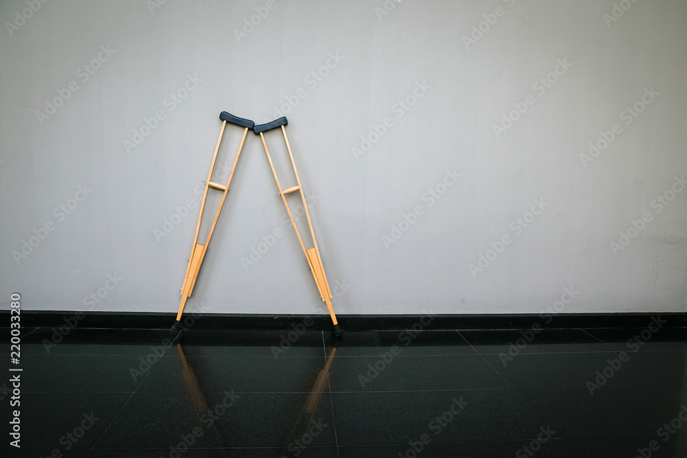 Crutches at wall.Success concept with crutches in the shadow of ladder ...