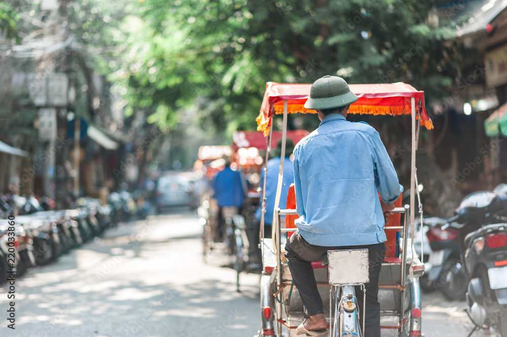 Traditional cyclo ride down the streets of Hanoi, Vietnam. The cyclo is ...