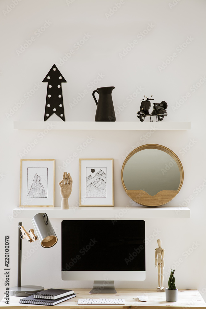 Wall shelves with decor and simple posters above wooden home office ...
