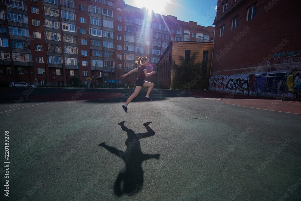 Red-haired young girl runs in the stadium. Student delivers standards ...