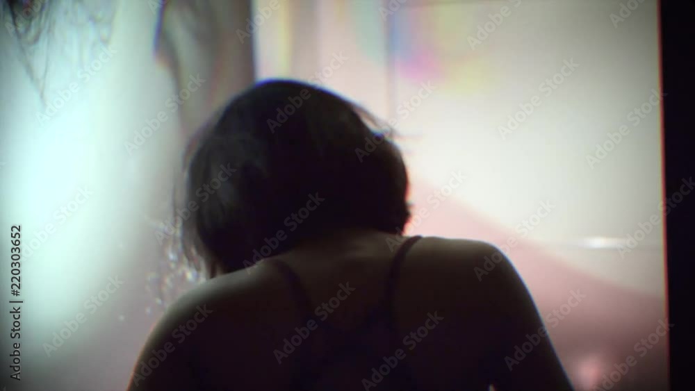 Scary zombie woman with wounds on her face staring at camera in dark at ...