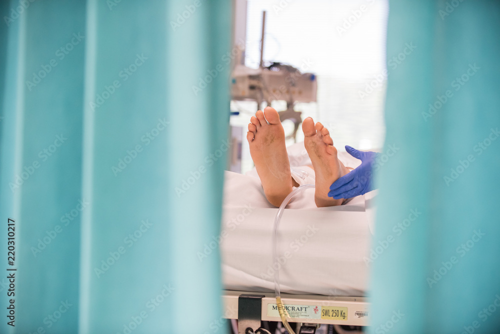A patient's feet viewed from behind the Intensive Care Unit hospital ...