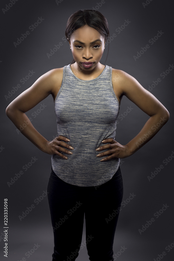 Black fitness trainer or athlete posing as a gritty woman on a dark ...