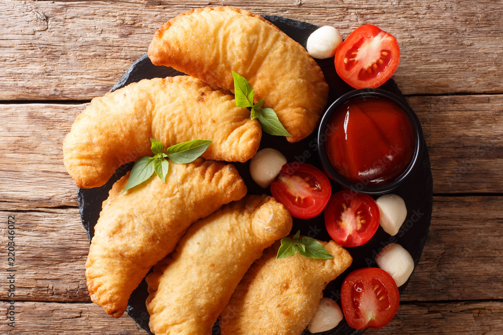 Spicy typical street Italian food: fried panzerotti with tomato sauce ...