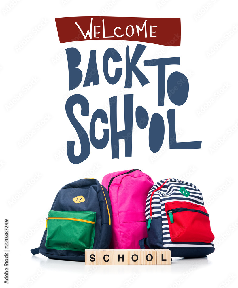 three colored schoolbags and wooden cubes with word school isolated on ...