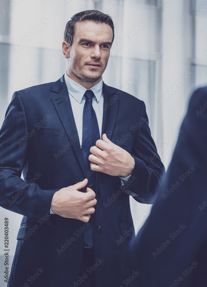 Power dressing. Handsome presentable man standing in a dressing room in ...