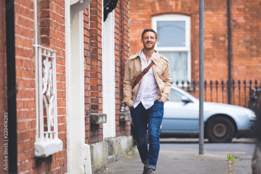 Man walking on side walk in the city Stock Photo | Adobe Stock
