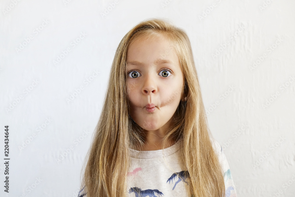 Portrait of a funny little girl being silly, making funny fish face ...