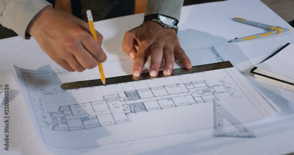 Top view on the Caucasian male hands of architect drawing a building ...