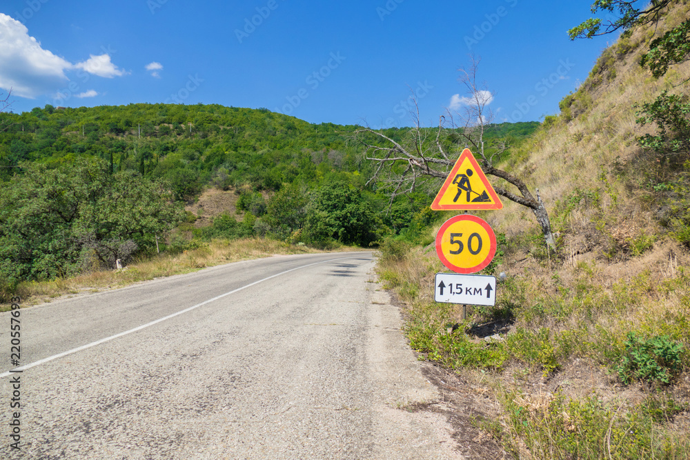 Country road with road signs, close up / Mountain forest road with ...