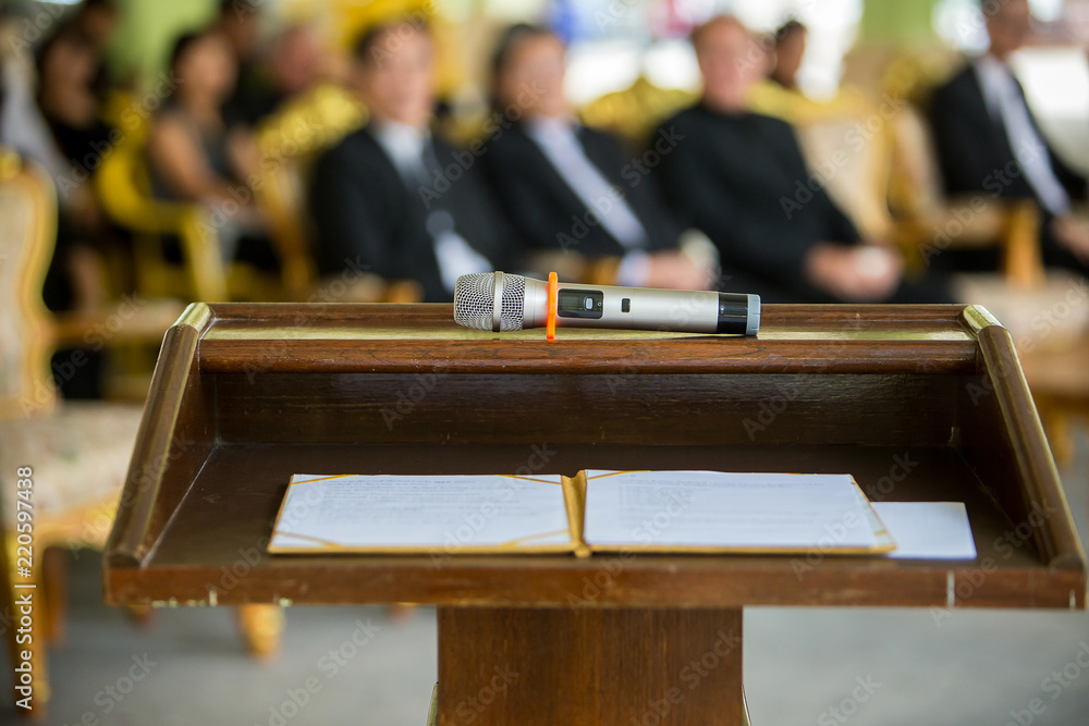 microphone placed on the podium in conference room with blur people ...