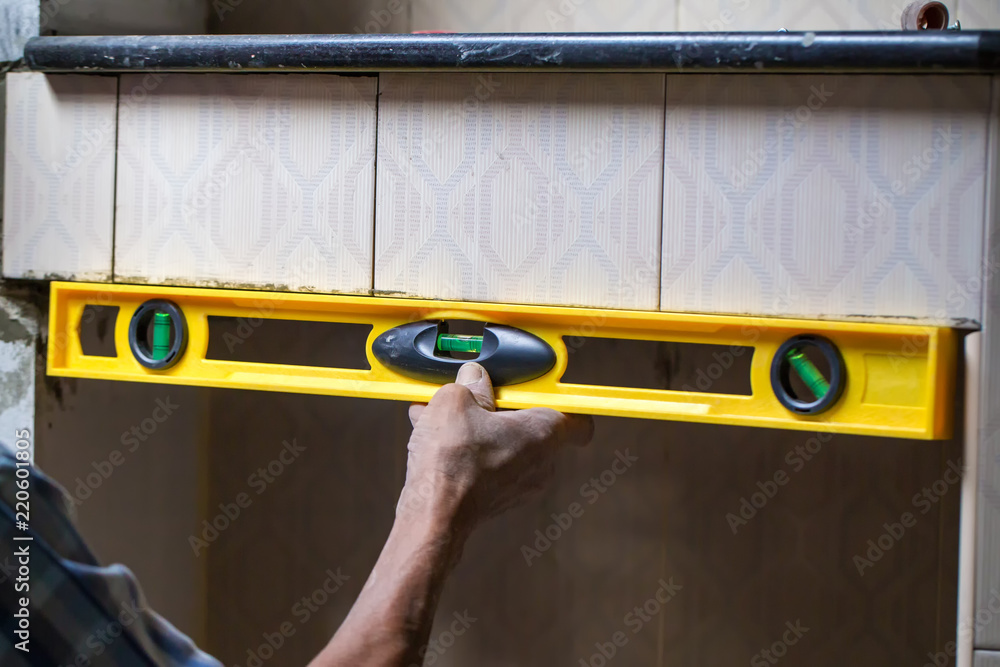 Industrial worker use building level to check balance edge of wall to ...