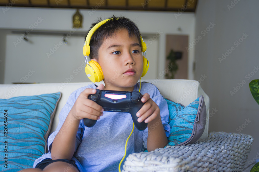 Latin young boy excited and happy playing video game online with ...