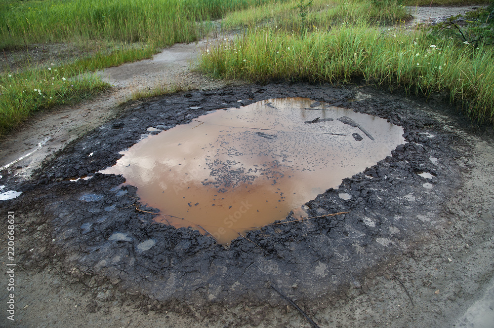Spills of crude oil on the soil surface. Crater of the mud volcano ...