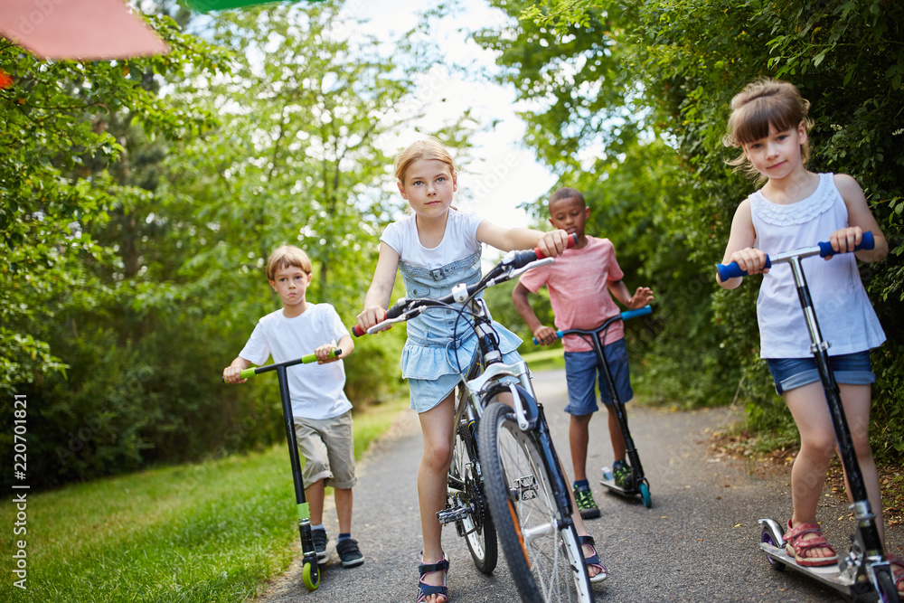 Group of kids riding bike and scooter Stock Photo | Adobe Stock