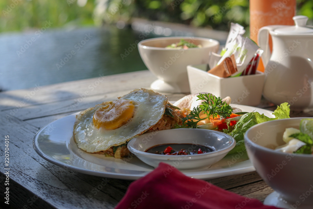 Breakfast by the pool in tropical resort in Bali. Exotic summer diet ...