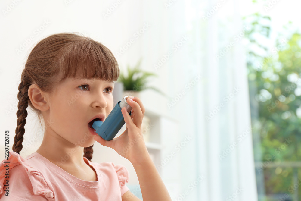 Little girl using asthma inhaler on blurred background Stock Photo ...