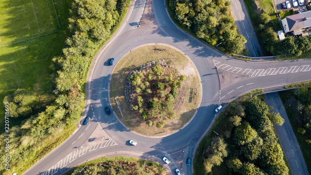 Top down aerial view of a traffic roundabout on a main road in an urban ...