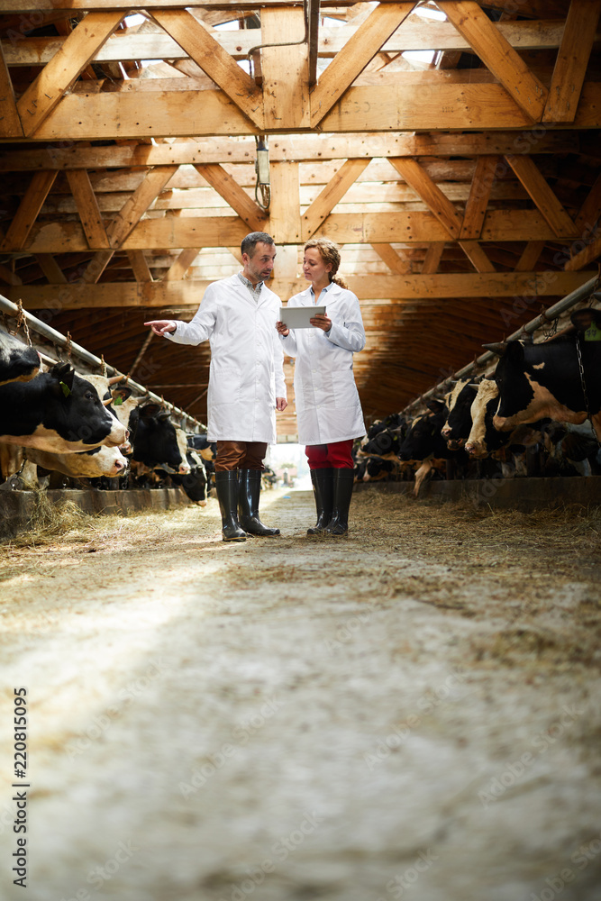 Full length portrait of two modern farm workers wearing lab coats ...
